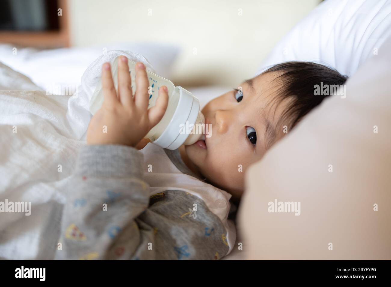 Asian Chinese baby boy age 1 to 2 drinking milk with holding milk ...