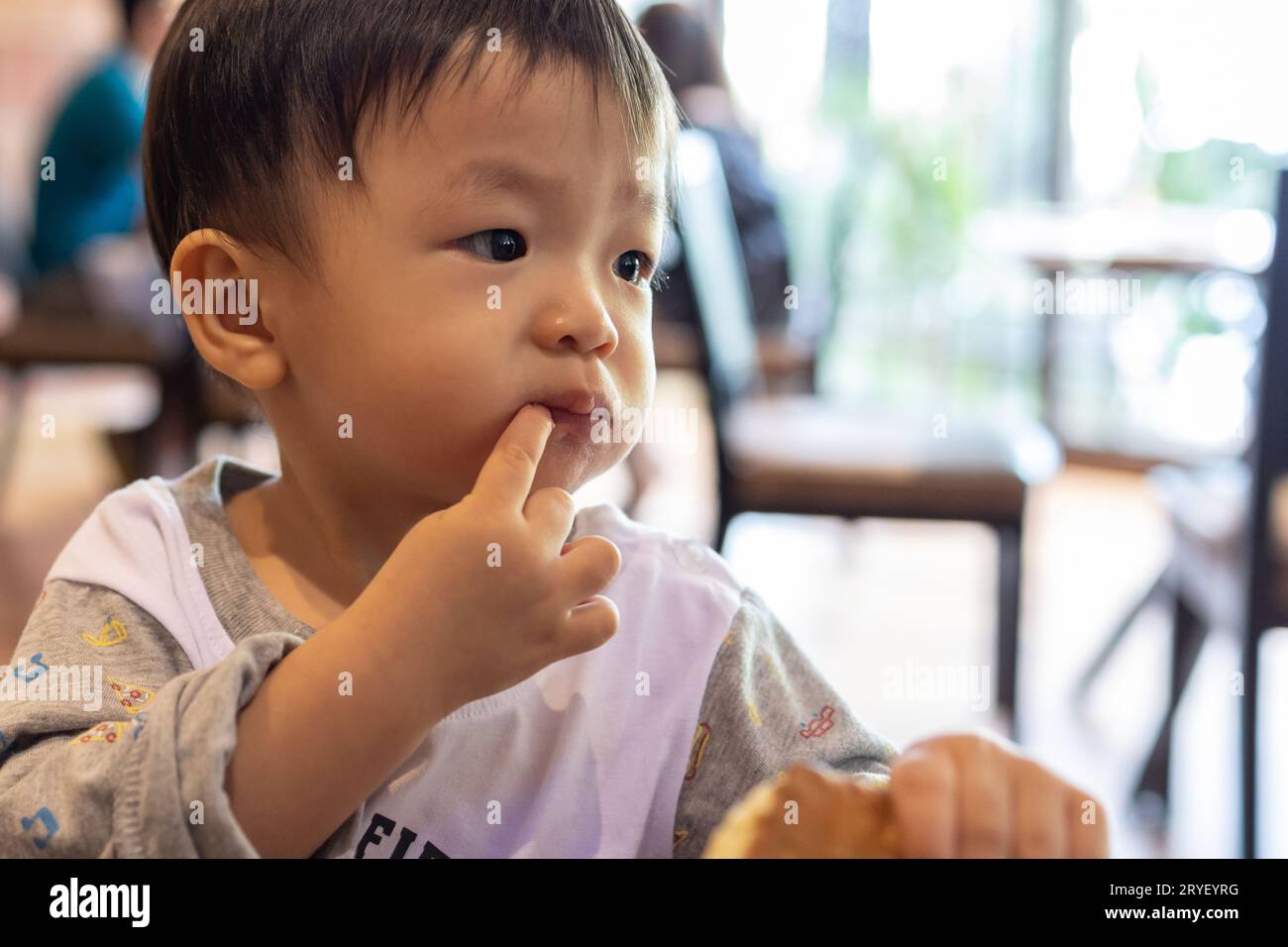 Happy Asian Chinese age 1-2 years old kid enjoying his food Stock Photo - Alamy
