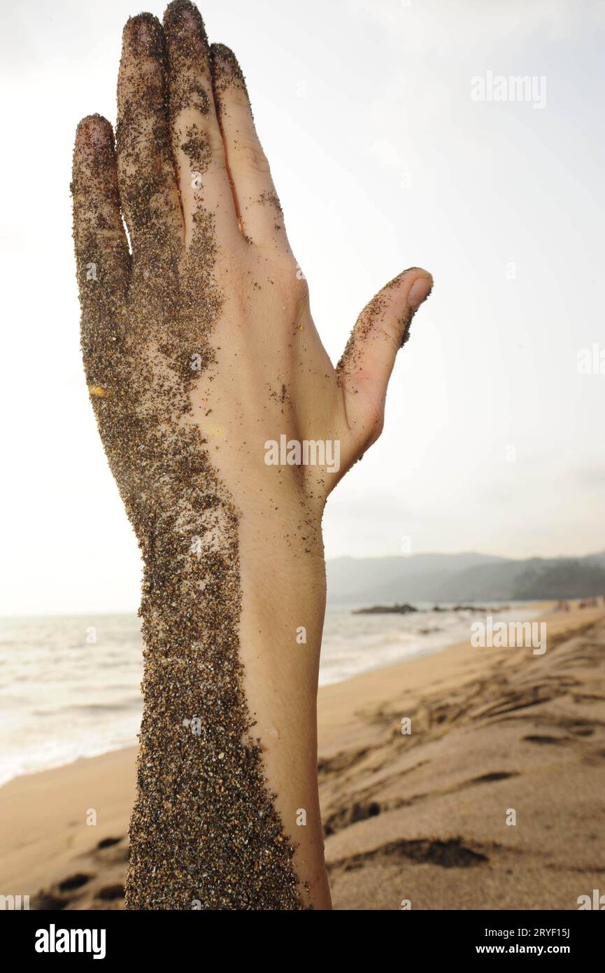 Arm half covered in sand at the beach Stock Photo - Alamy
