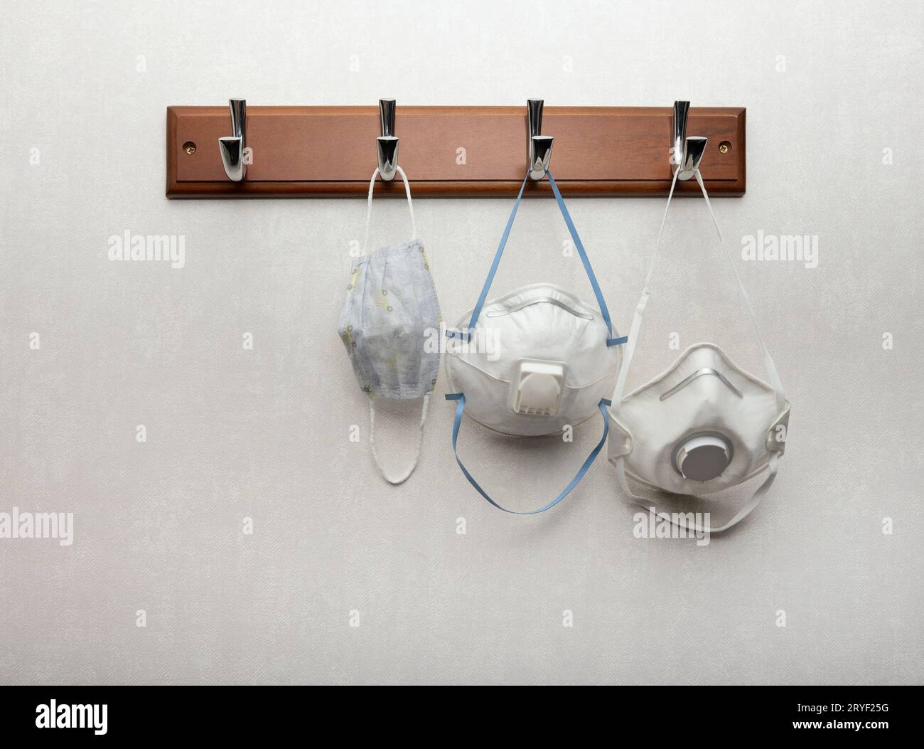 Several respirator masks hanging on clothes rack Stock Photo - Alamy