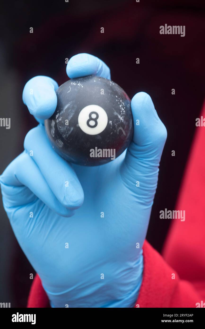 Person holding the black number eight ball in their hand Stock Photo ...