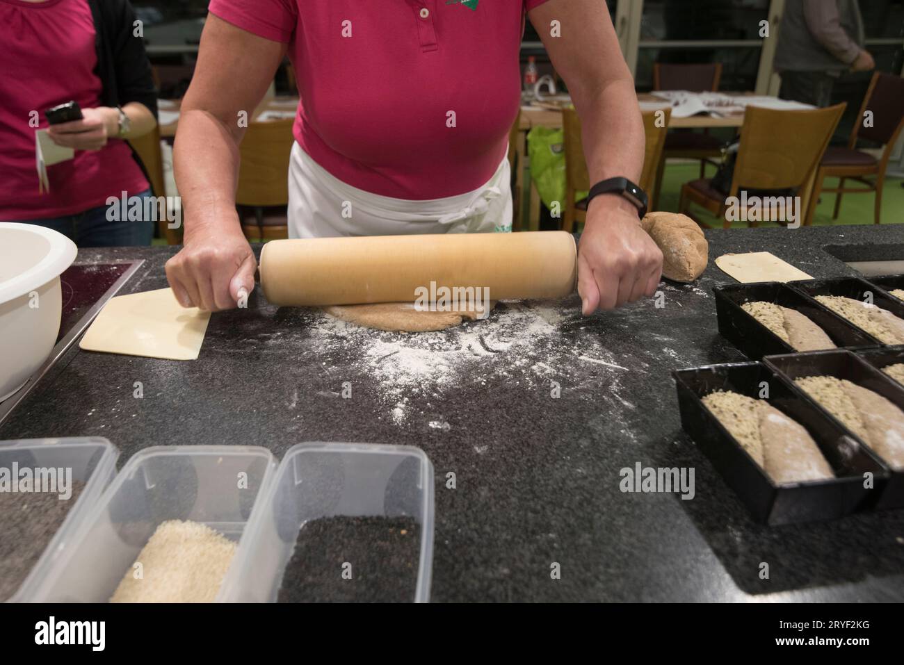 Woman using a rolling pin forming bread dough Stock Photo - Alamy