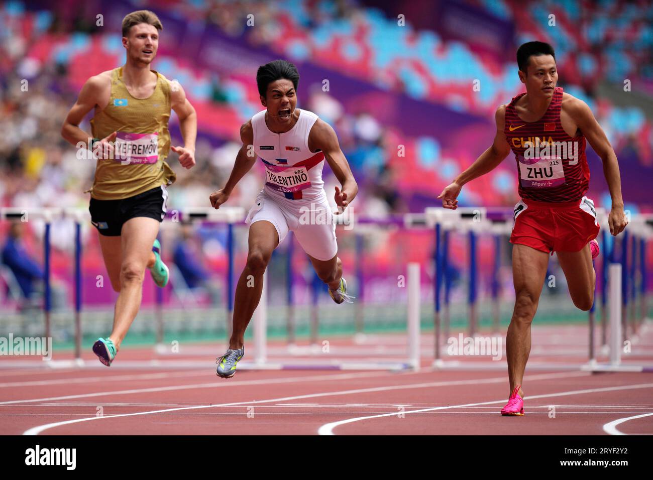 Philippines' John Tolentino, center, reacts as he crosses the finish ...