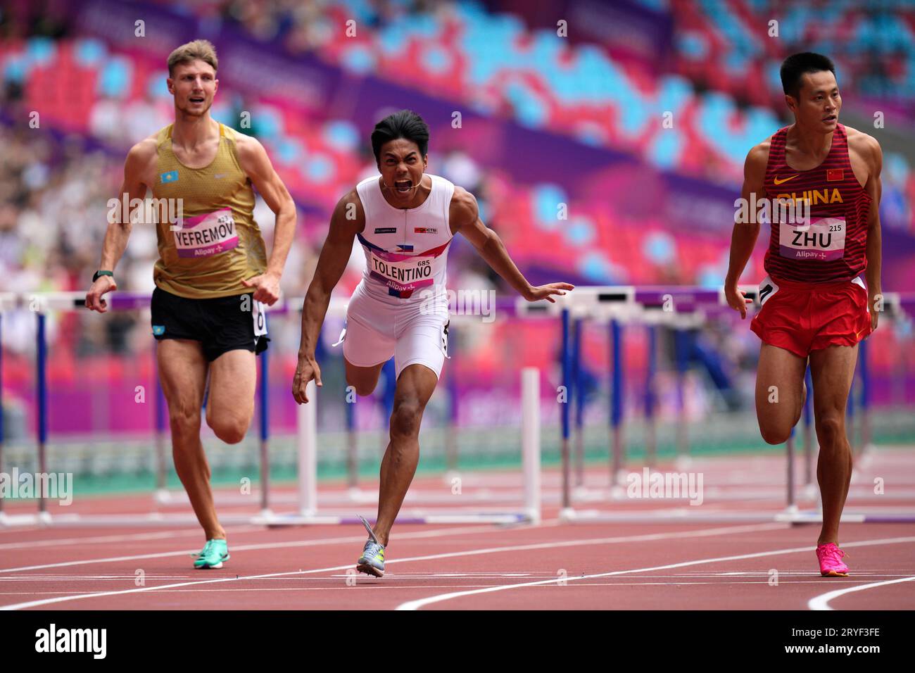 Philippines' John Tolentino, center, reacts as he crosses the finish ...