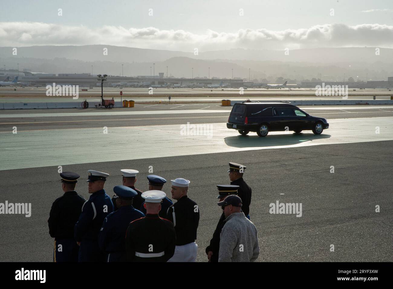 A hearse and color guard wait at the San Francisco International ...
