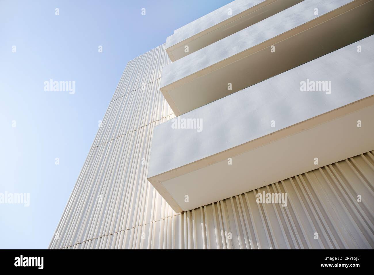Low angle view of balconies on a modern building facade. Decorative white concrete facade. Copy ...