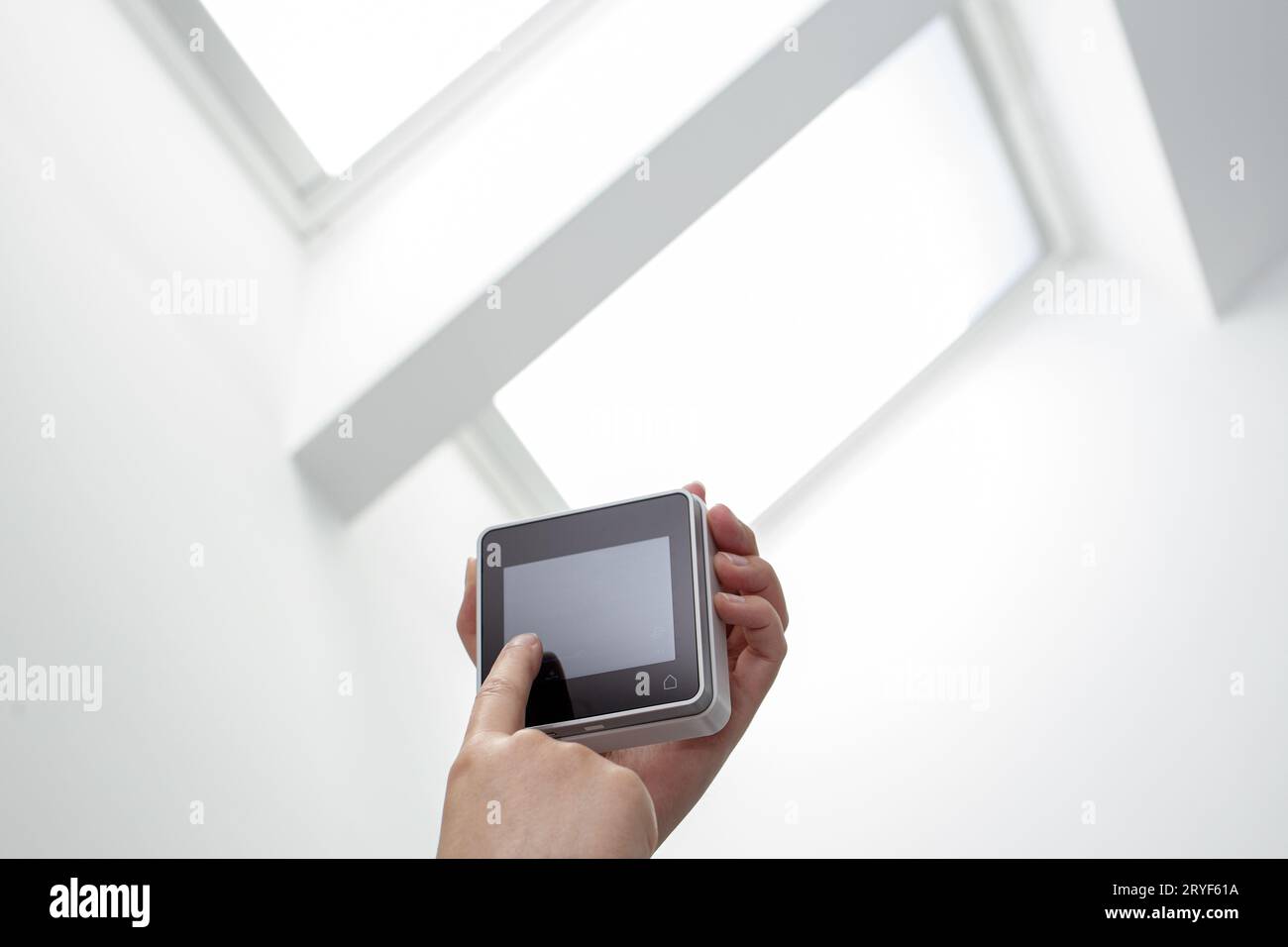 Hand operating a Remote control of a roof windows on indoor. Copy space ...