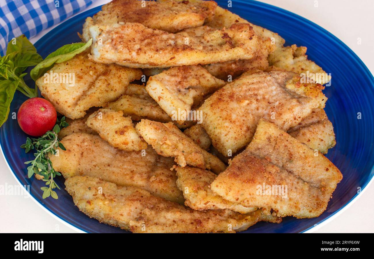 crispy fried fish pieces on o blue plate on white background, tasty ...