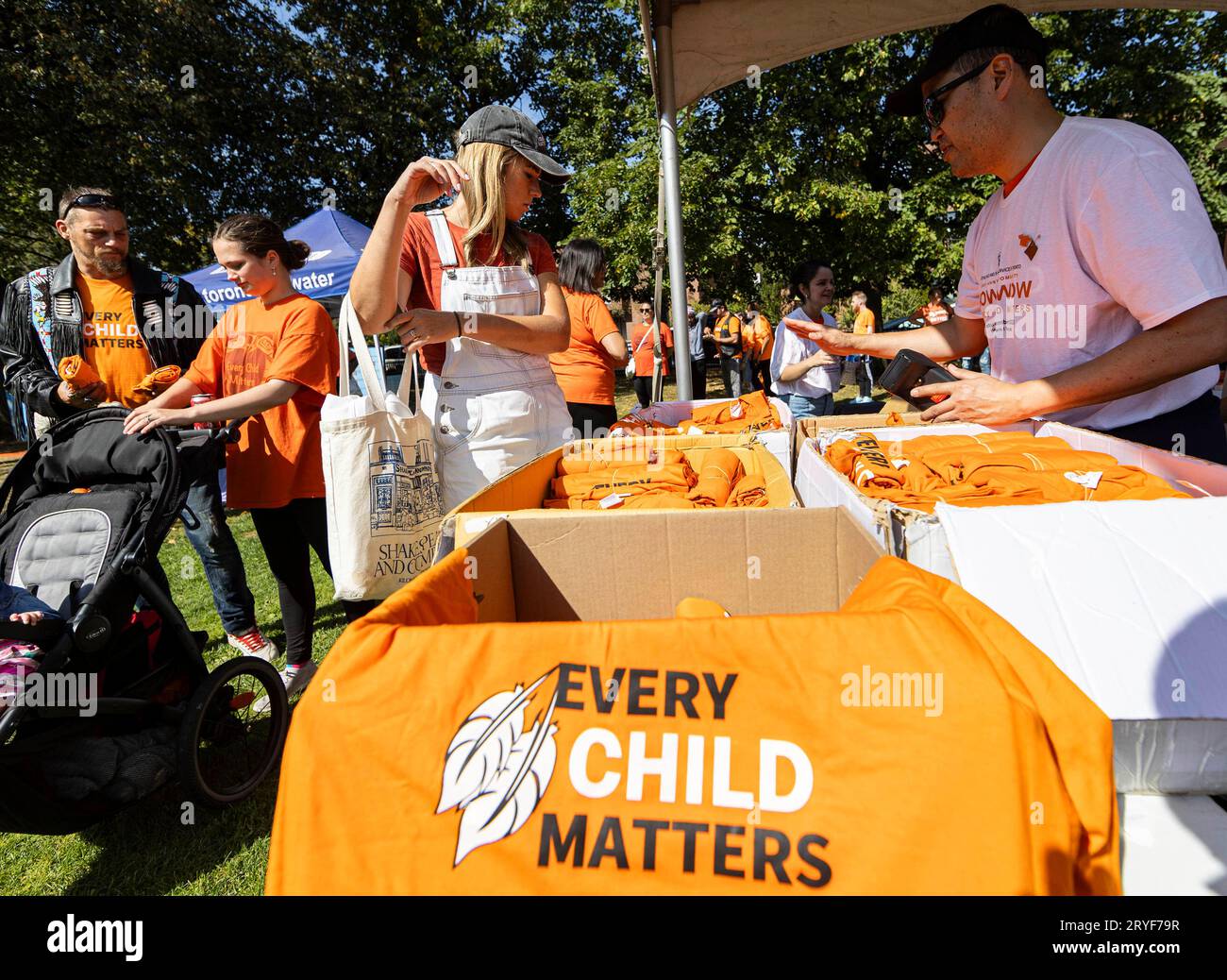 Toronto, Canada. 30th Sep, 2023. A woman selects orange T-shirts with ...