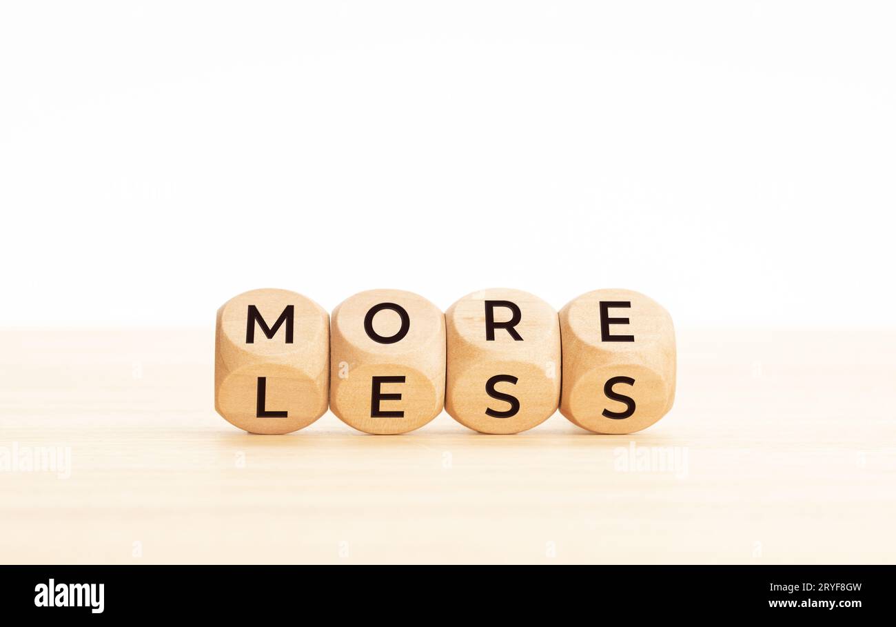 More and less word on changing wooden blocks. Copy space. White ...