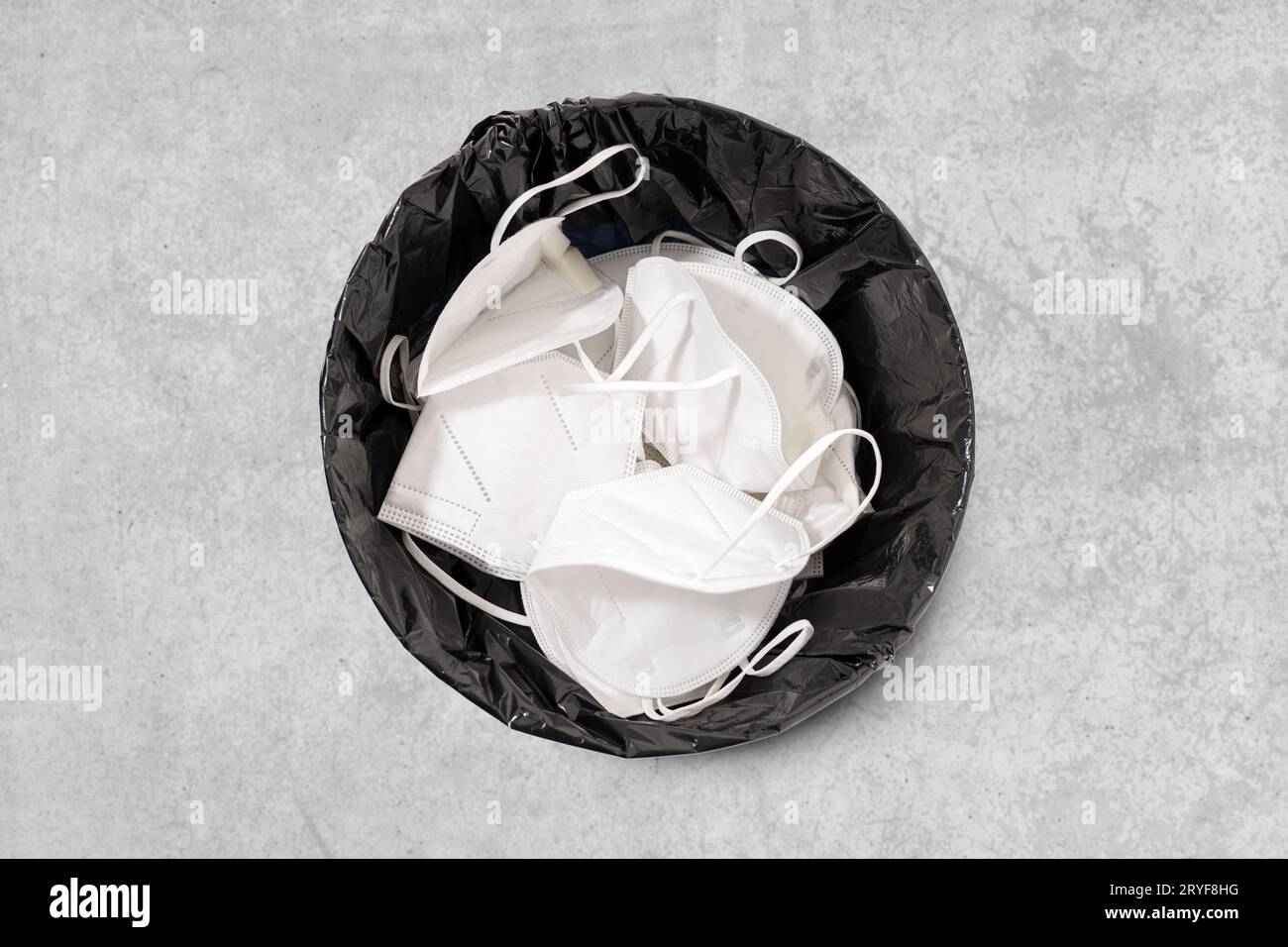 Trash can full of used face mask. Covid-19 protective wear waste ...