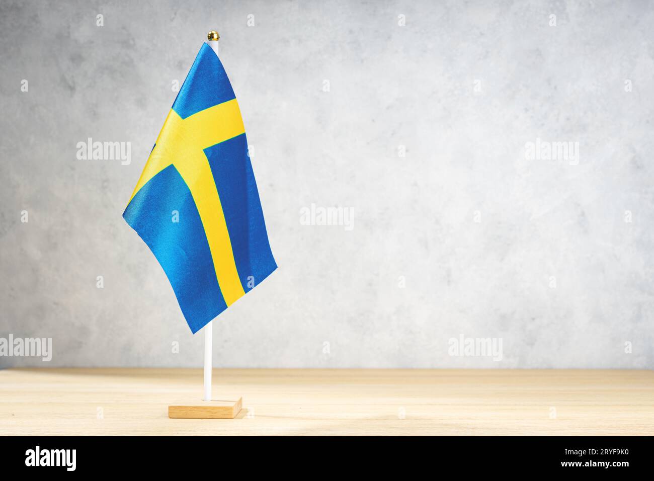 Sweden table flag on white textured wall. Copy space for text, designs ...