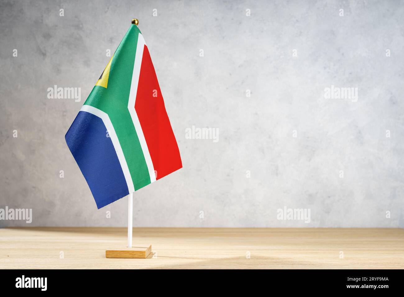 South Africa table flag on white textured wall. Copy space for text ...