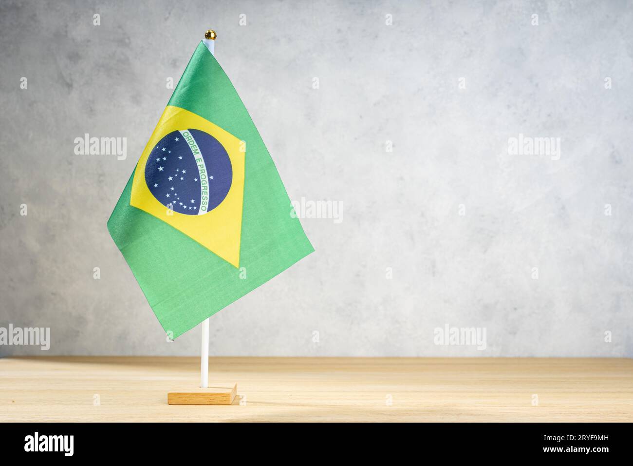 Brazil table flag on white textured wall. Copy space for text, designs ...