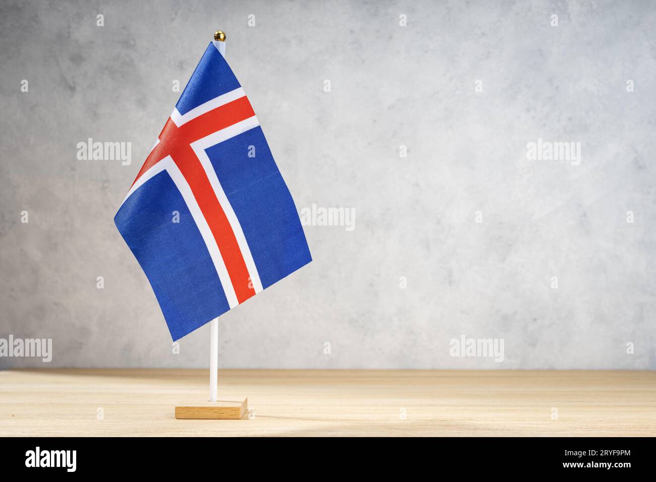 Iceland table flag on white textured wall. Copy space for text, designs ...