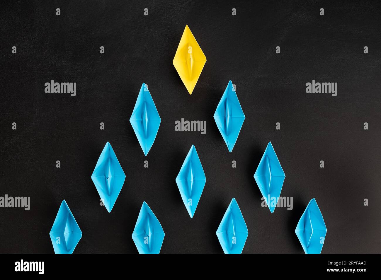 Leadership concept. Group of paper boat on blackboard background. One ...