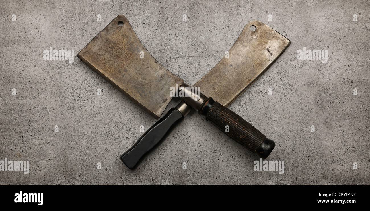 Two crossed vintage meat cleavers on table Stock Photo - Alamy