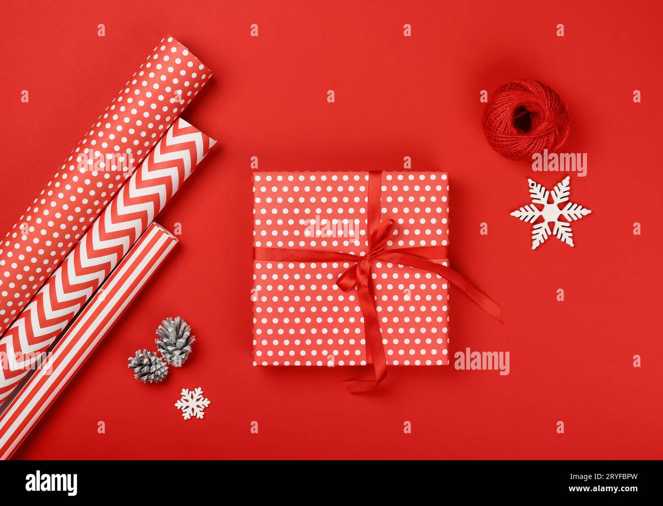 Packing Christmas gifts with red and white paper Stock Photo - Alamy