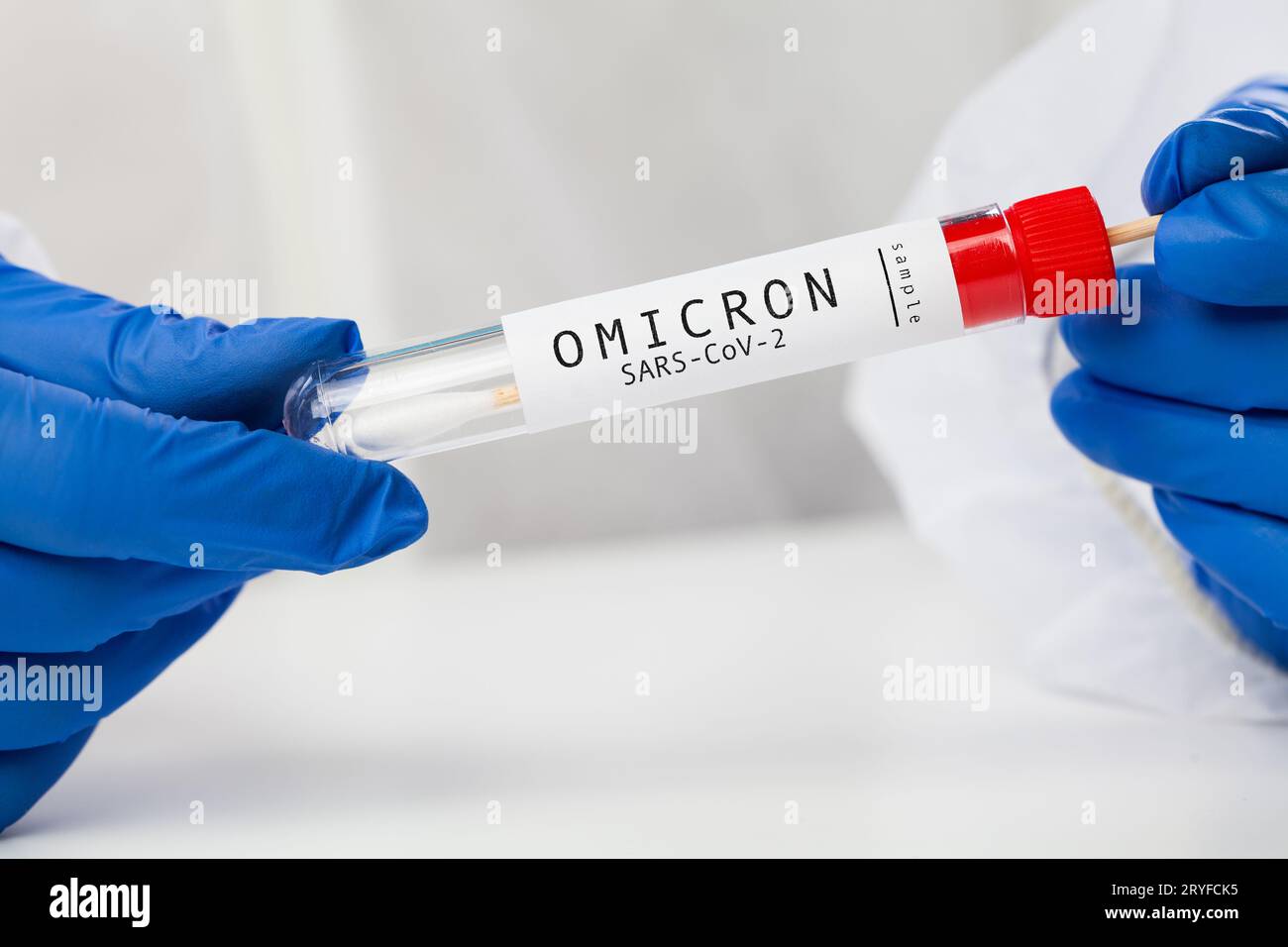 Medical NHS healthcare professional holding COVID-19 Omicron virus swab ...