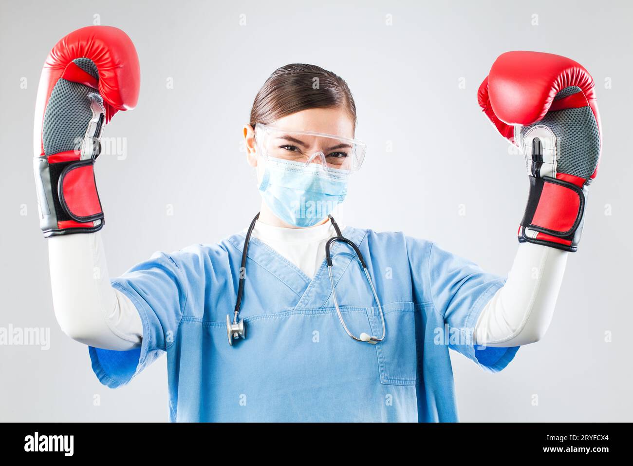 Female doctor wearing red boxing gloves celebrating with arms raised ...