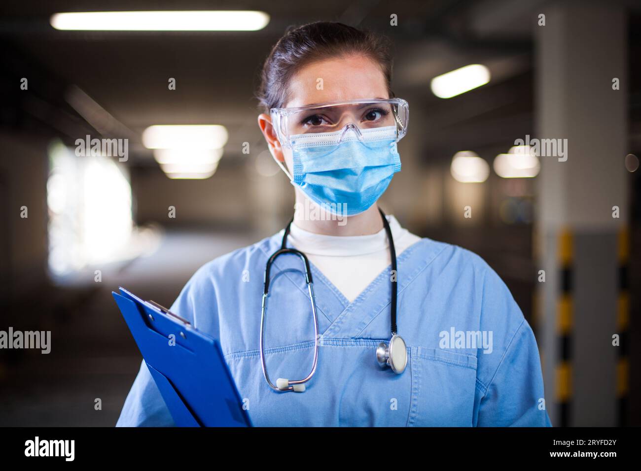 Portrait of young serious female medic in hospital ambulance parking ...