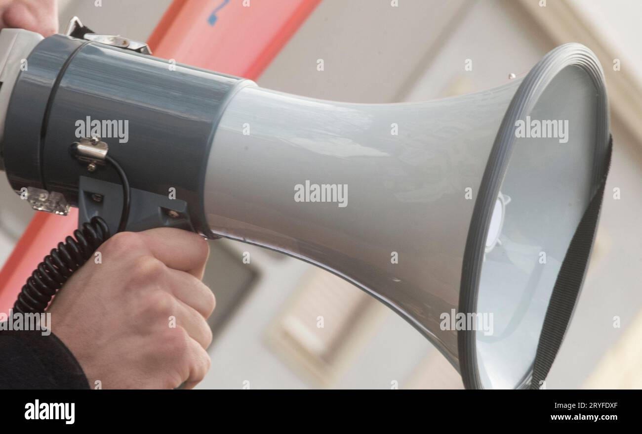 speaking into a megaphone, loud talking and communication to a group of ...