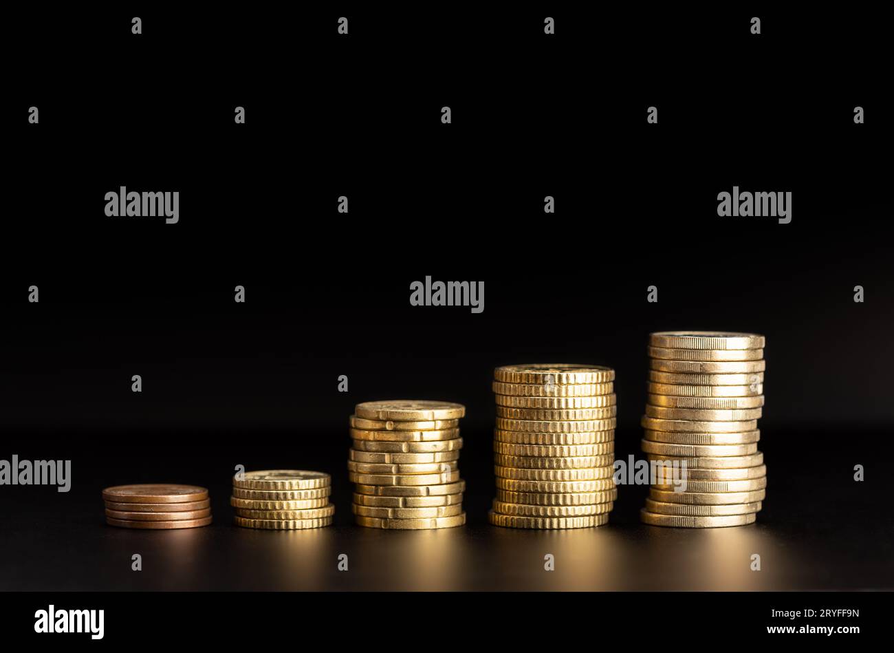 Rising Coin stacks on black background. Growth, income, savings concept ...