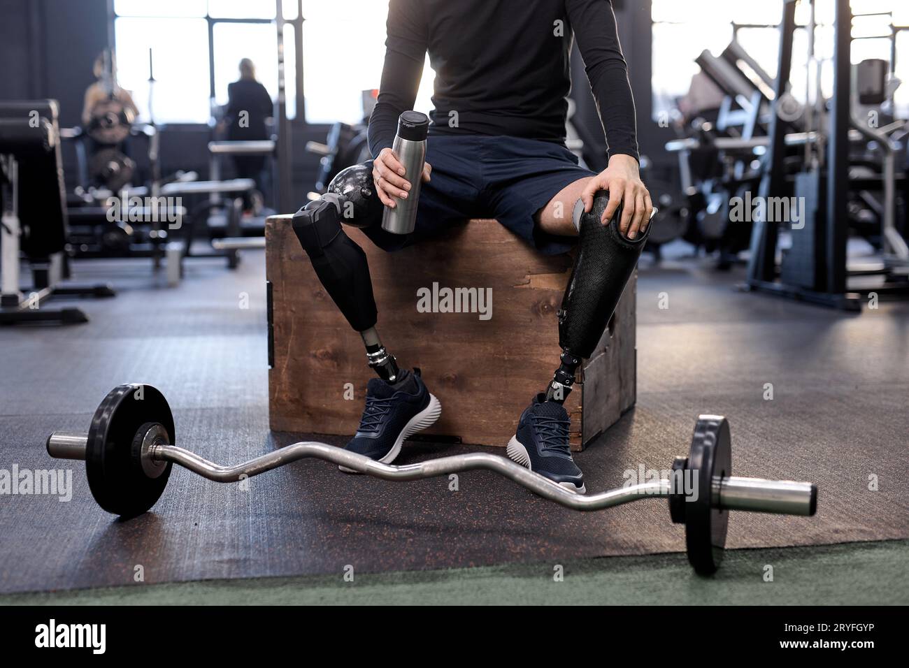 exhausted young slim man holding thermos, water in hand sitting at ...