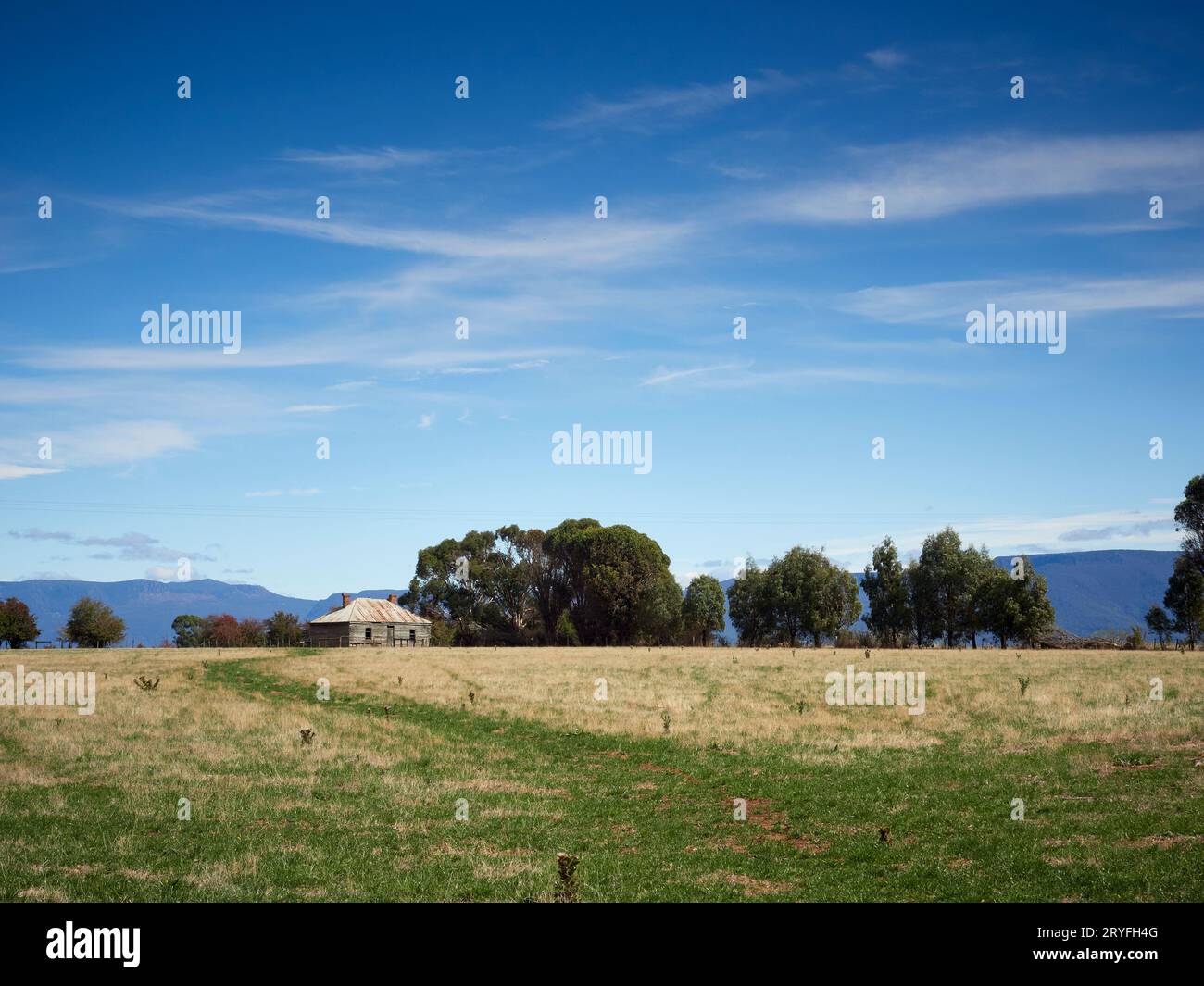 Rural abandoned typical Australian property. Huge blue skies with wispy ...