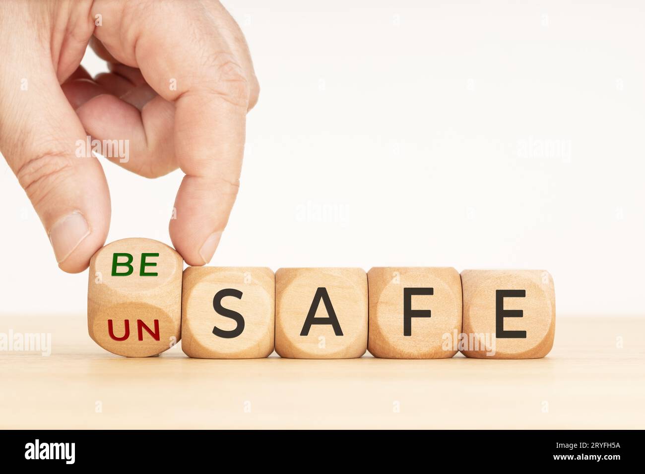 Hand flipping a wooden block with unsafe and be safe words. Copy space ...