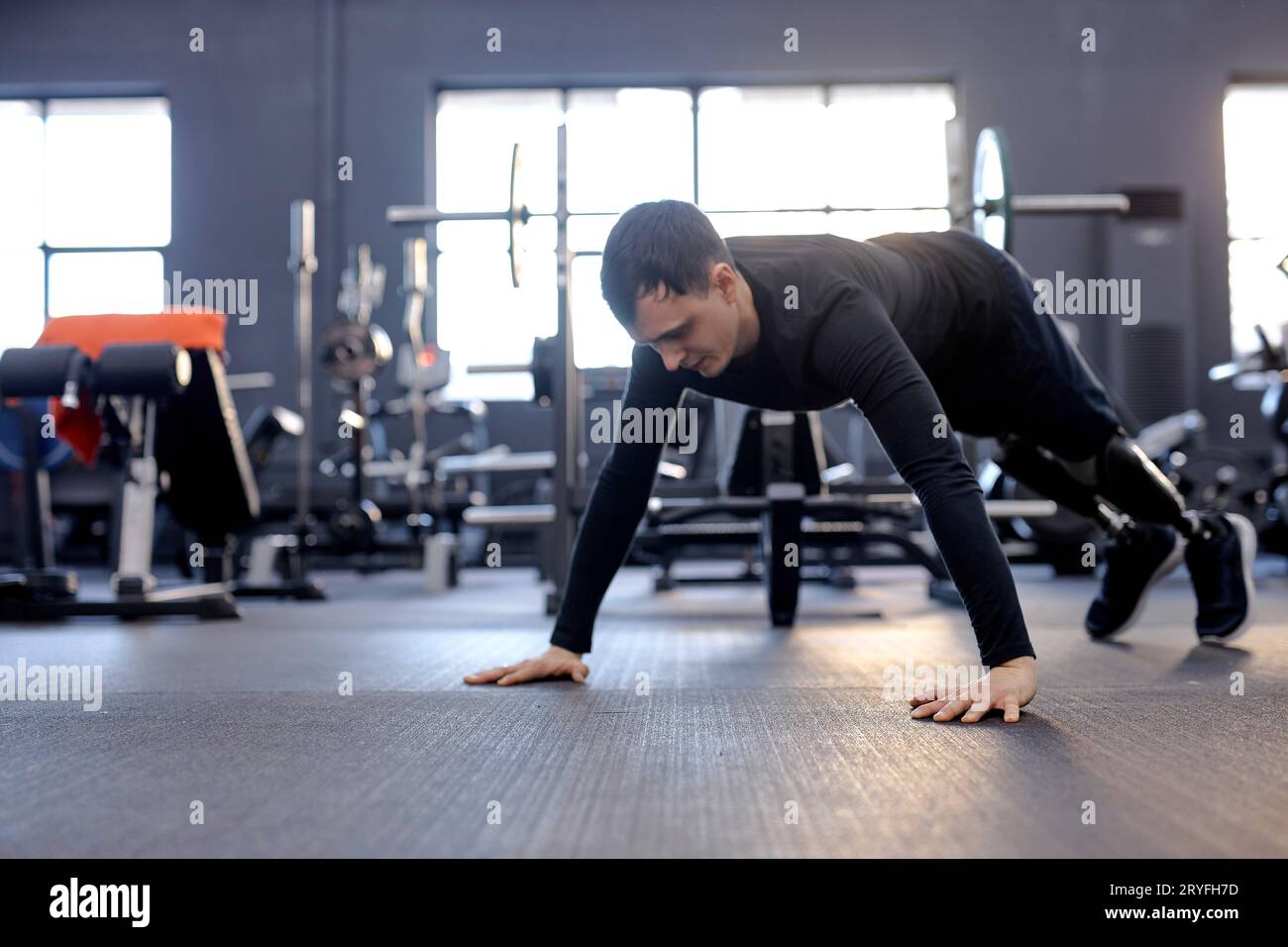serious ambitious young sportsman with artificial legs doing push ups ...