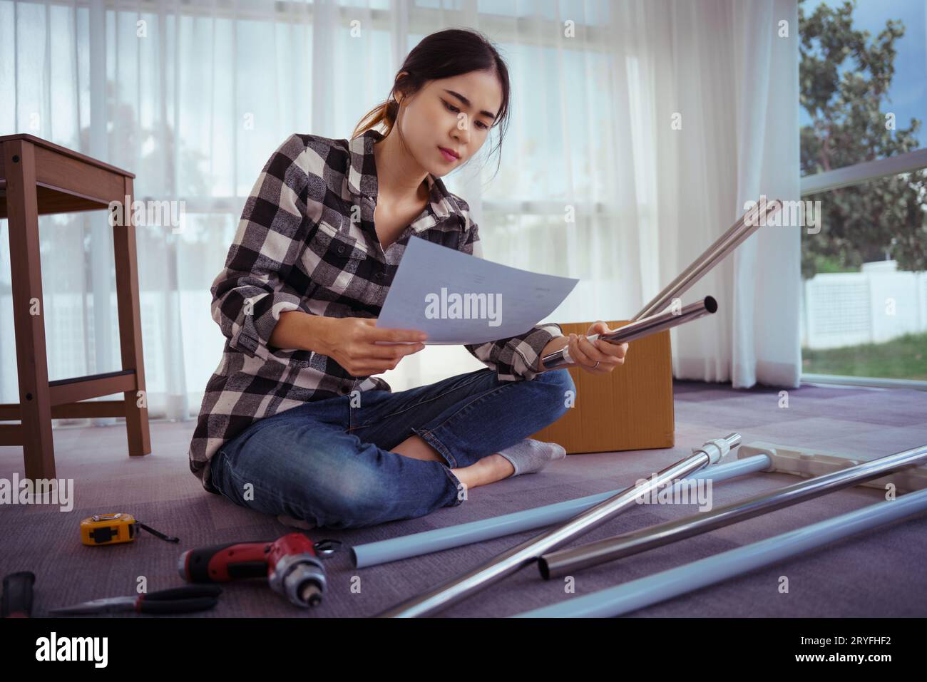 Women sitting on floor to reading installation manual and instruction ...