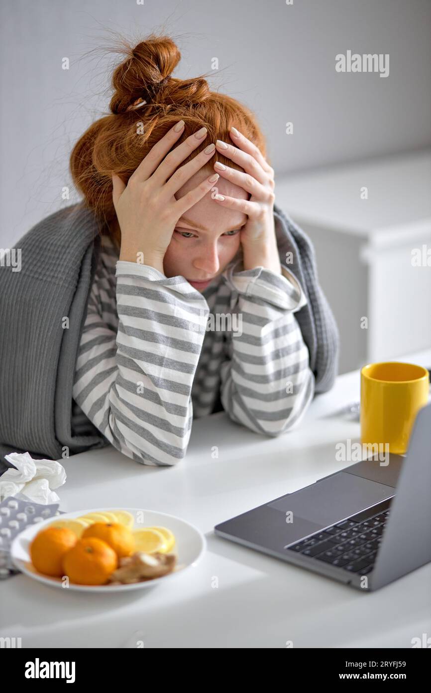 sad frustrated female student touching her head, using laptop, has ...