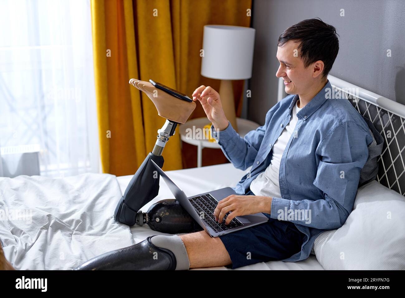 impaired man with artificial leg prosthesis checking messages and ...