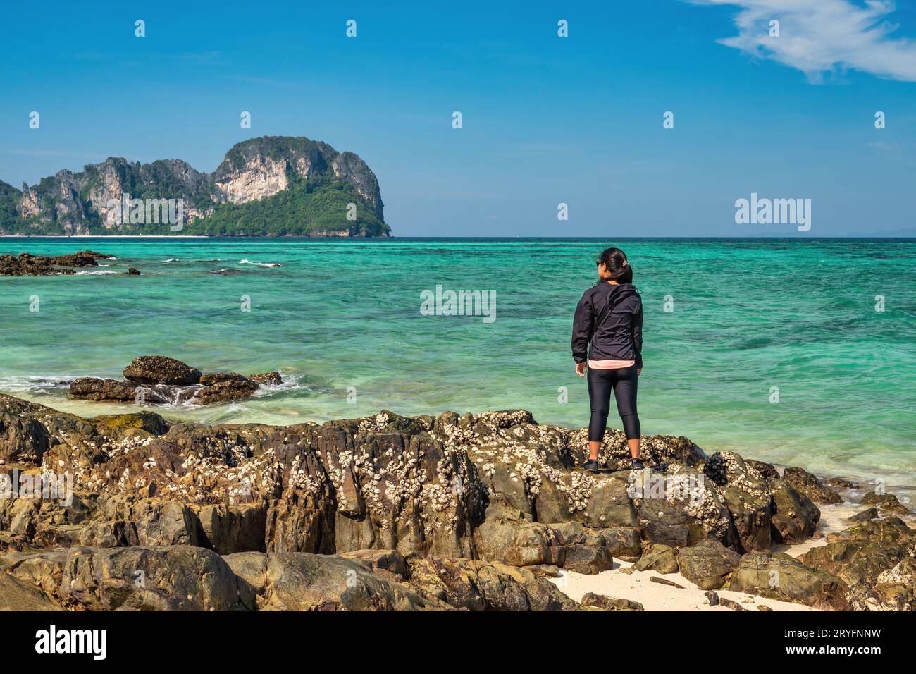 Tropical islands view with woman tourist looking at ocean blue sea ...