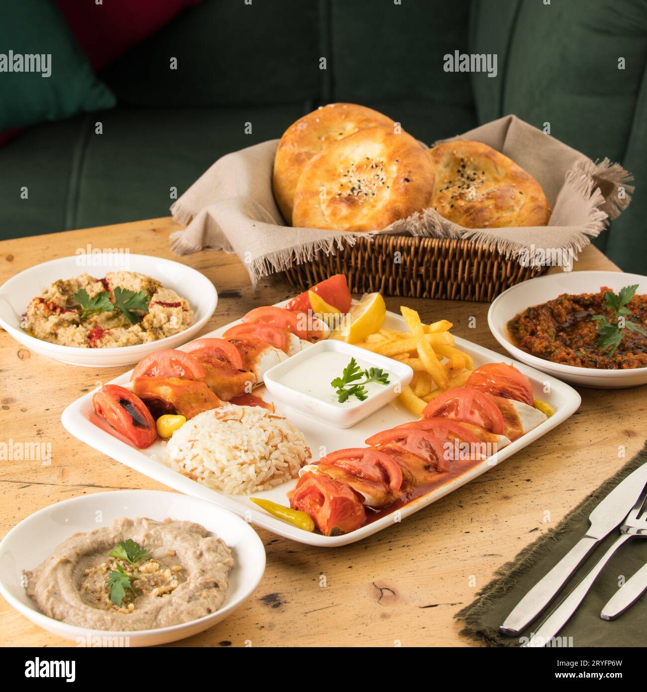 Dining table full of delicious dishes and a basket of bread Stock Photo ...