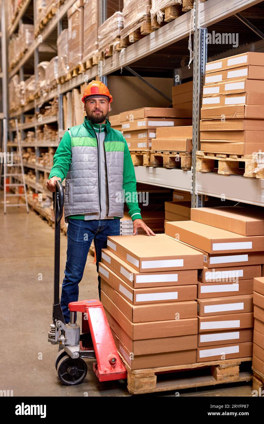 caucasian warehouse worker with manual pallet jack, working in storage ...