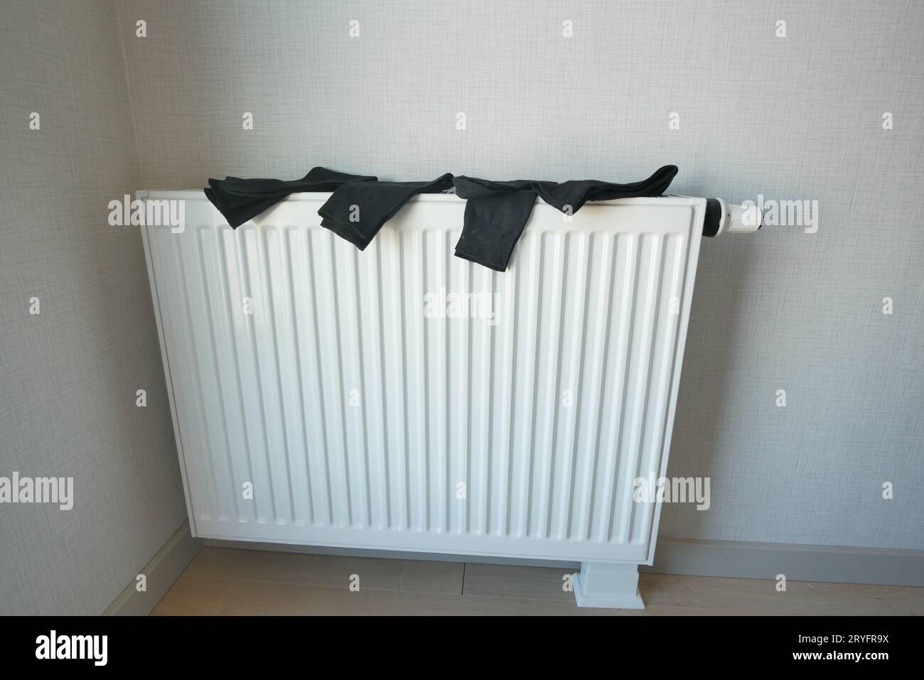 black sock drying on heating radiator Stock Photo - Alamy