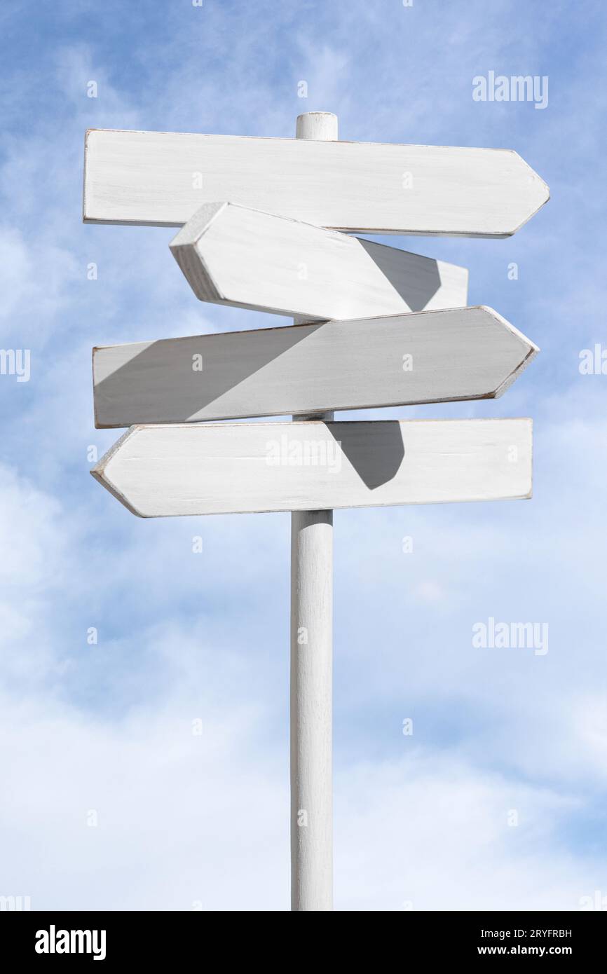 Blank white signpost with blue sky with white clouds background. Choose ...
