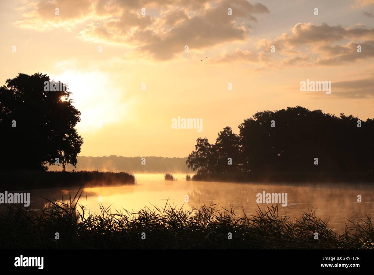 Sunrise over a lake Stock Photo - Alamy