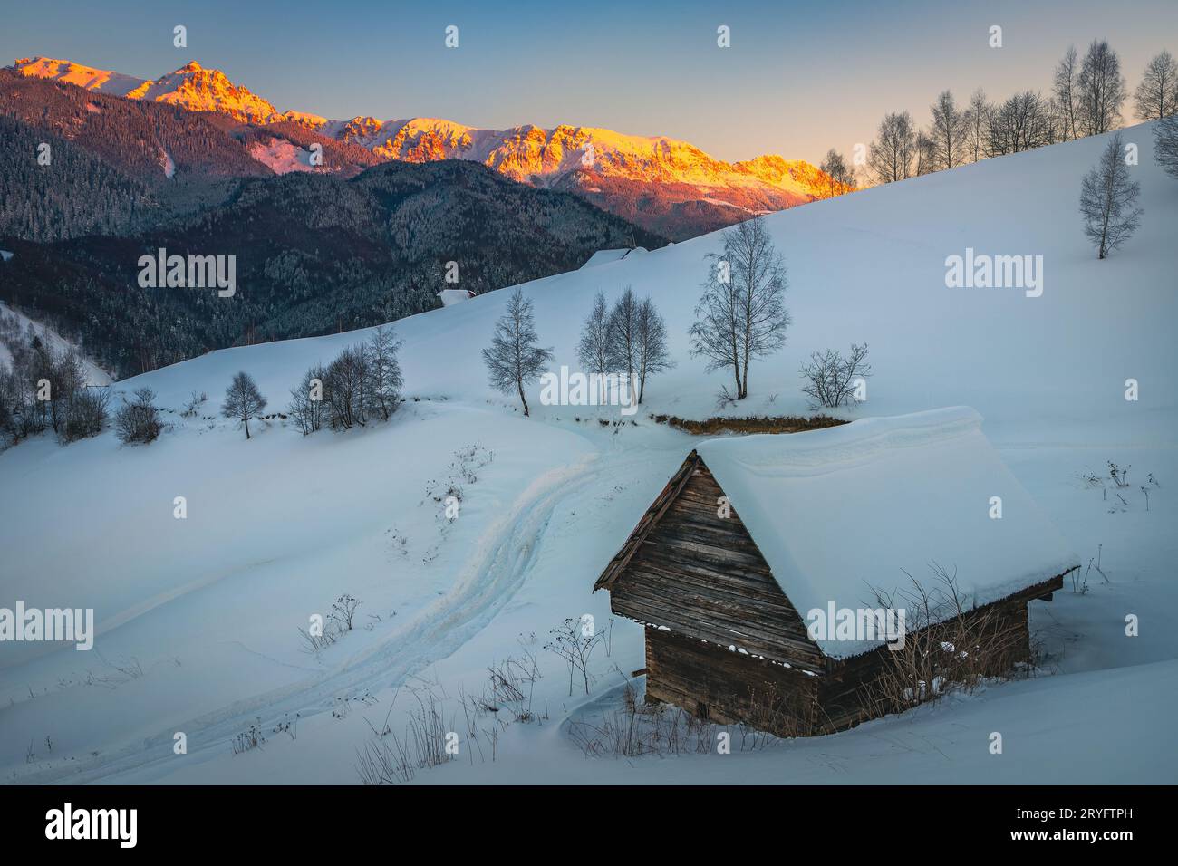 Stunning winter scenery with snowy wooden hut on the slope and ...