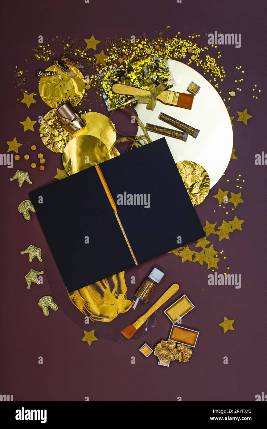 Notepad with black paper and golden stationery and items for creativity ...