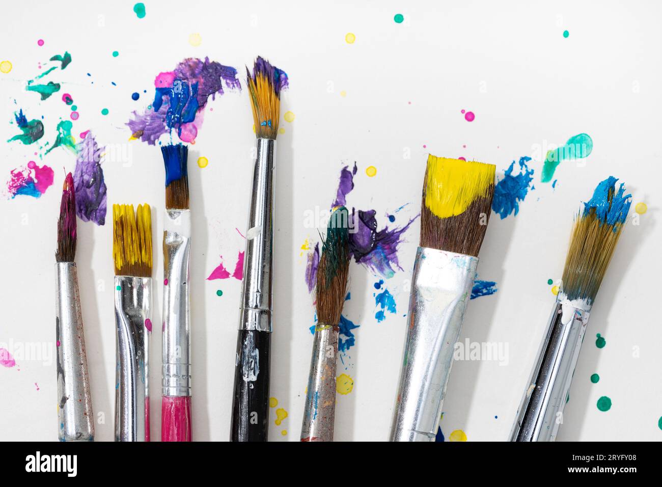 Group of Art Paint brushes and colorful splatter on white canvas paper ...