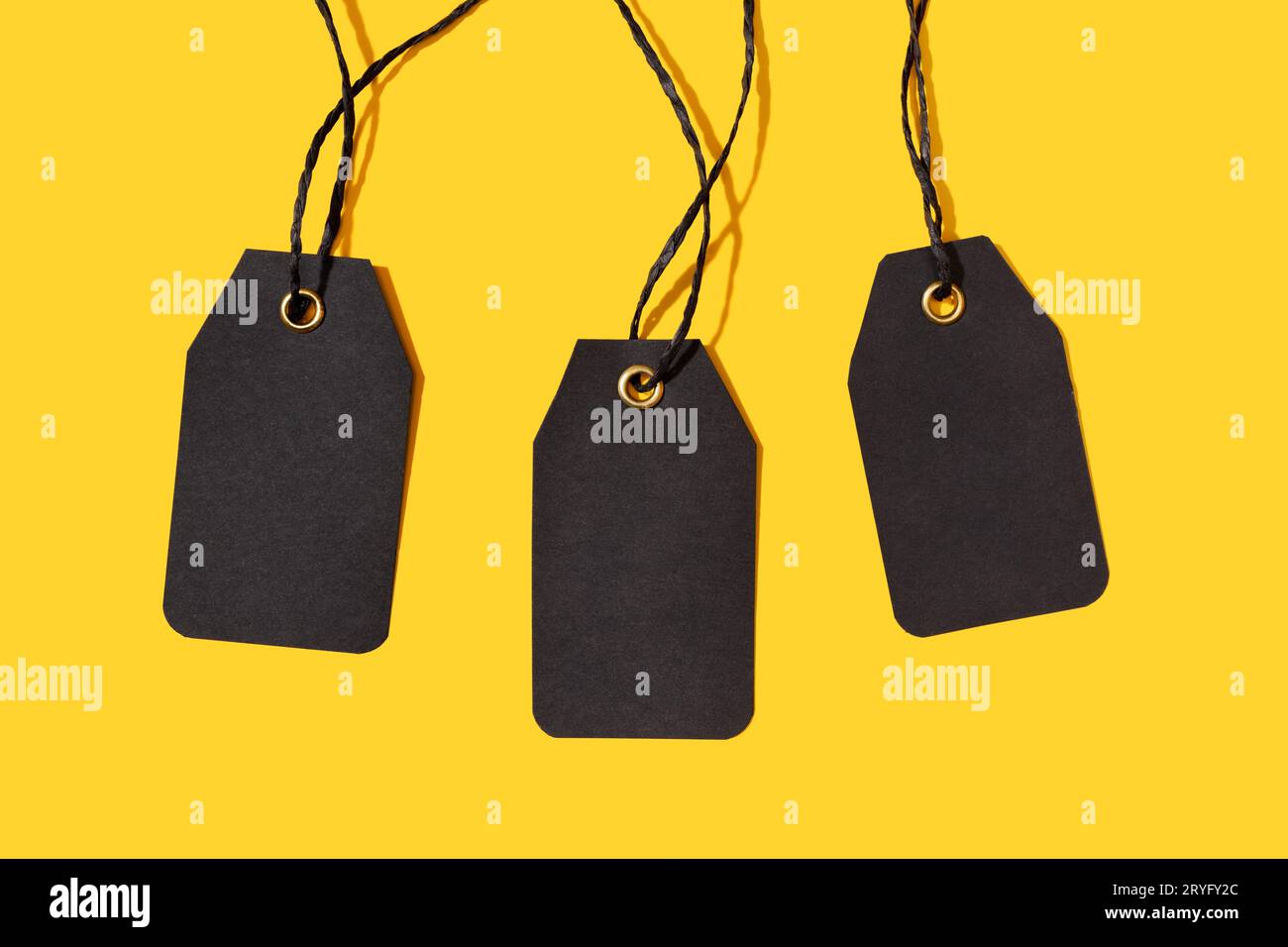 Group of three Blank black tags isolated on yellow background. Template ...