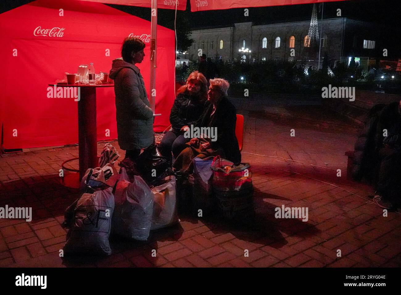 Refugees are seen standing next to tents with their belongings on the ...