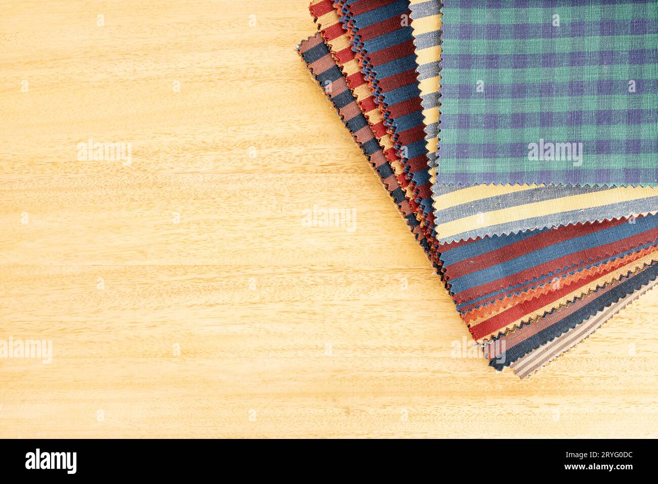 Fabric textile catalog on wooden table. Fabric samples upholstery and ...