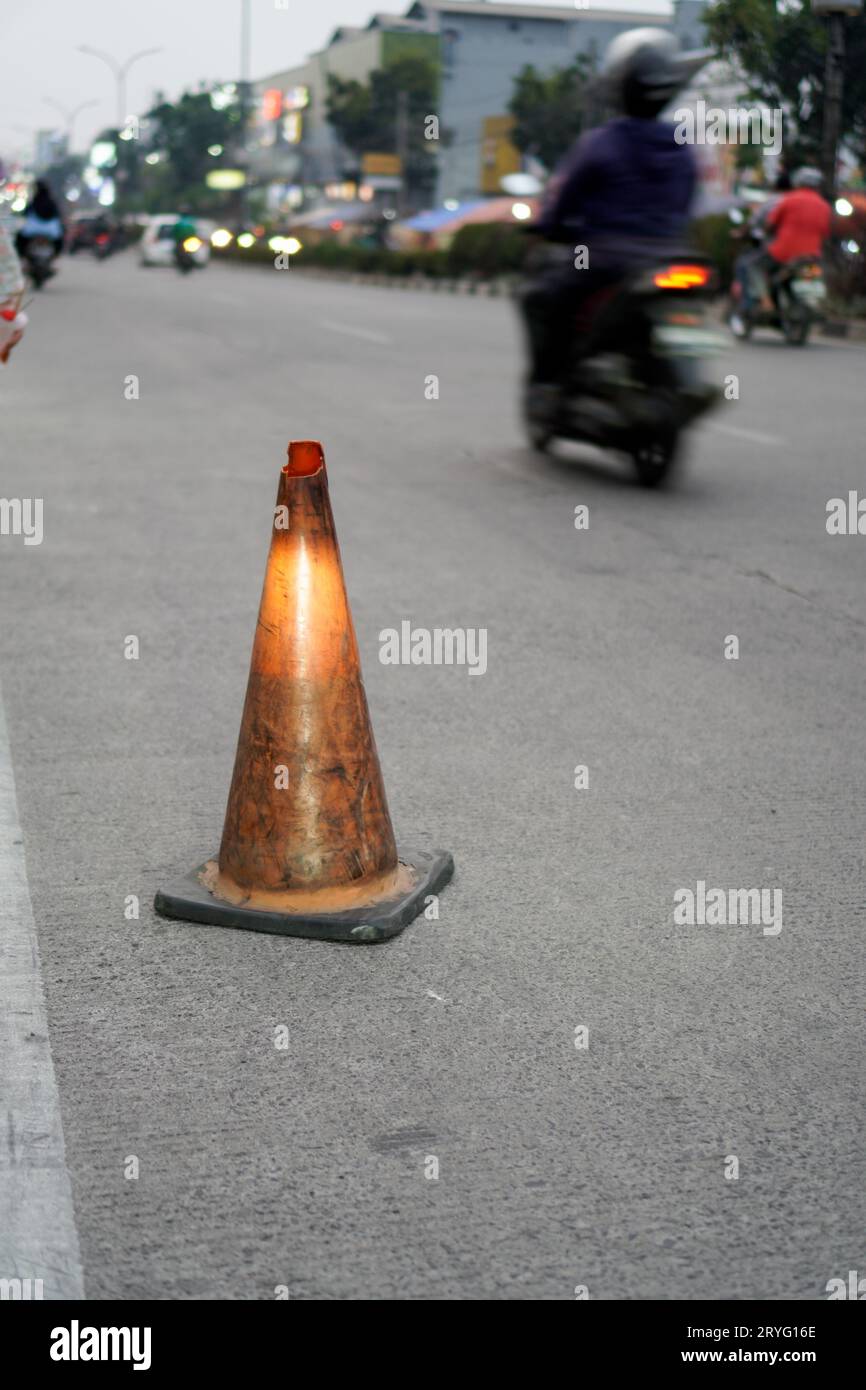 An orange roadblock next to the road, a sign for some potholes on the ...