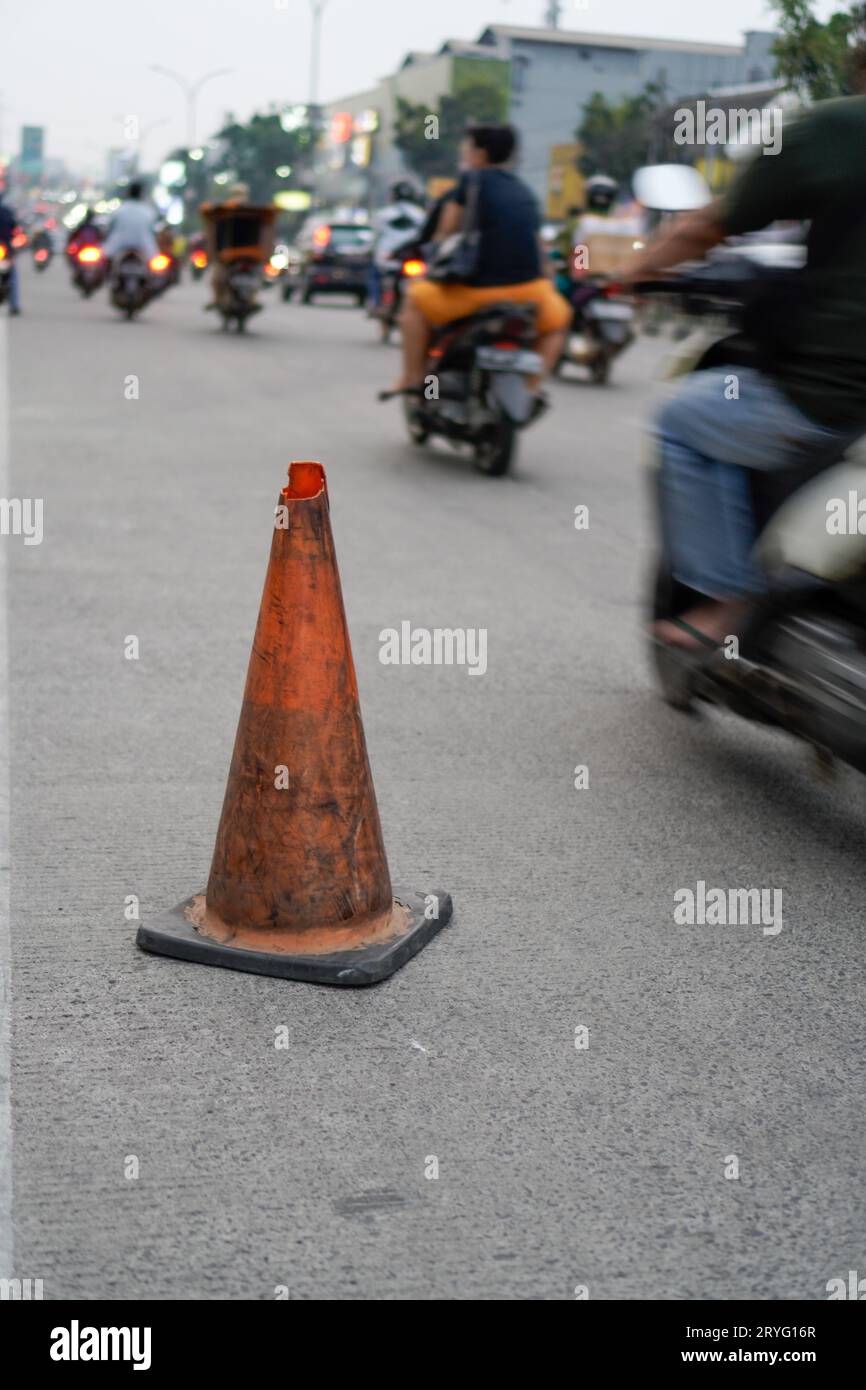 An orange roadblock next to the road, a sign for some potholes on the ...