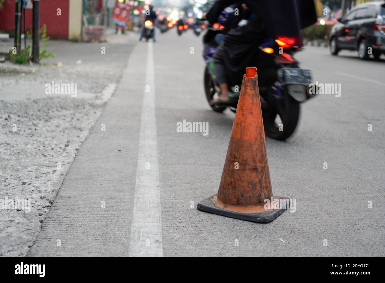 An orange roadblock next to the road, a sign for some potholes on the ...