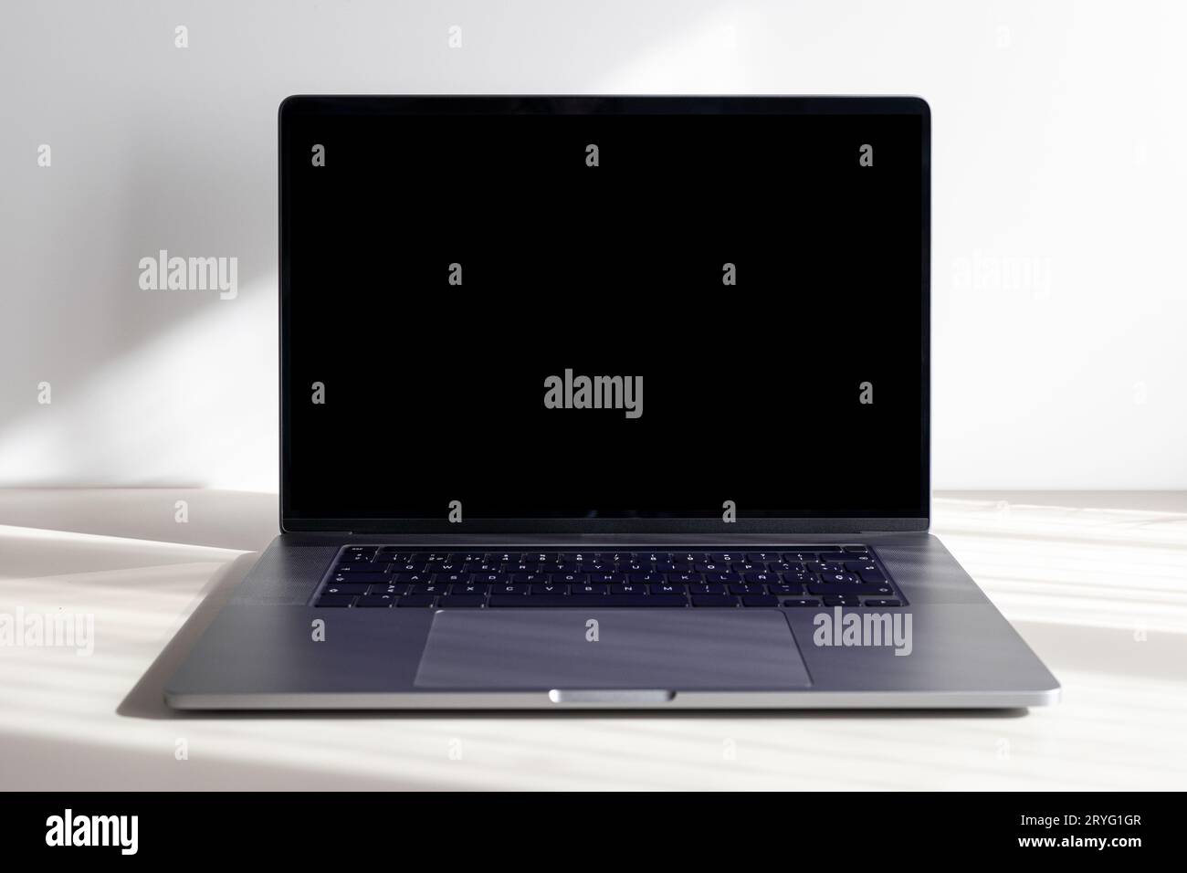 Front view of Modern laptop with empty black screen on minimalist desk ...